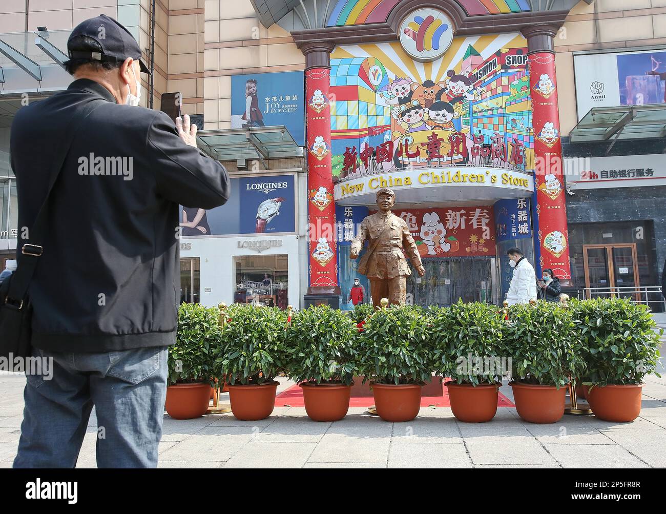 People take photos in front of the bronze statue of Lei Feng, a Chinese ...