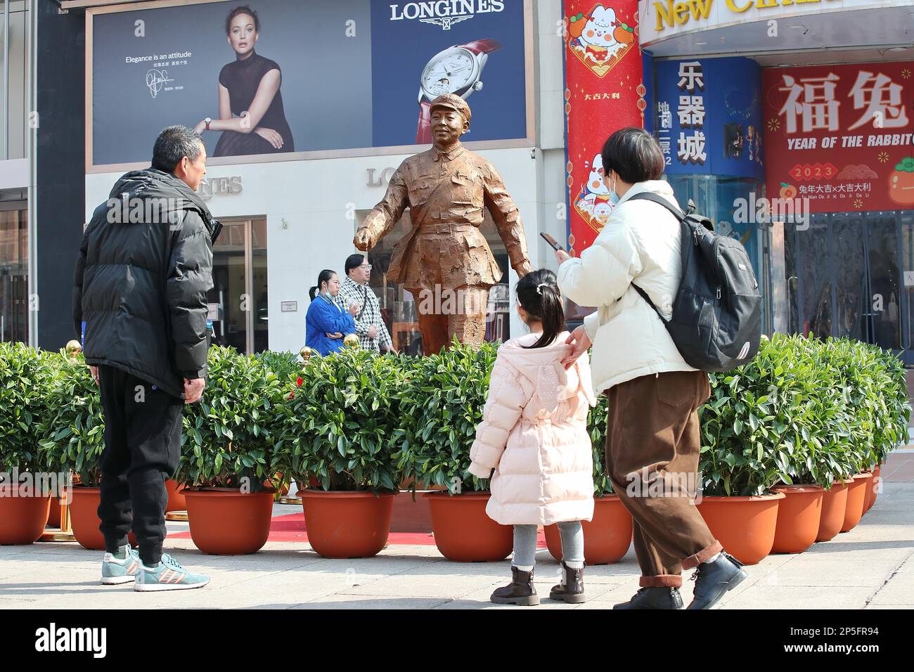 People take photos in front of the bronze statue of Lei Feng, a Chinese ...