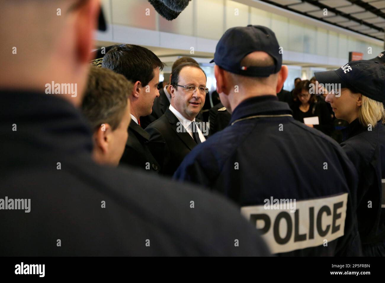 French President Francois Hollande, center, speaks with police officers ...