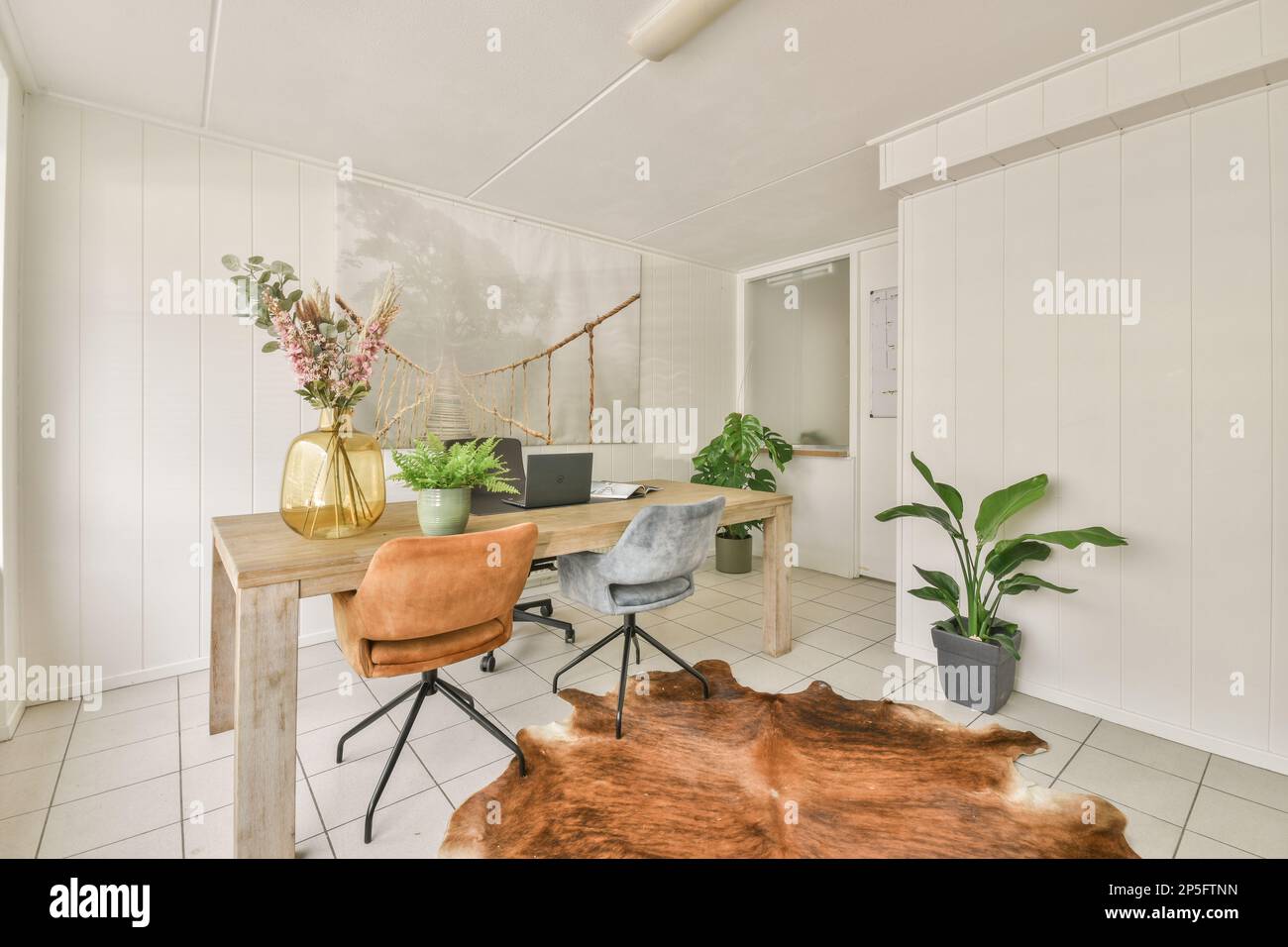 a living room with a cow skin rug on the floor and an office desk in ...