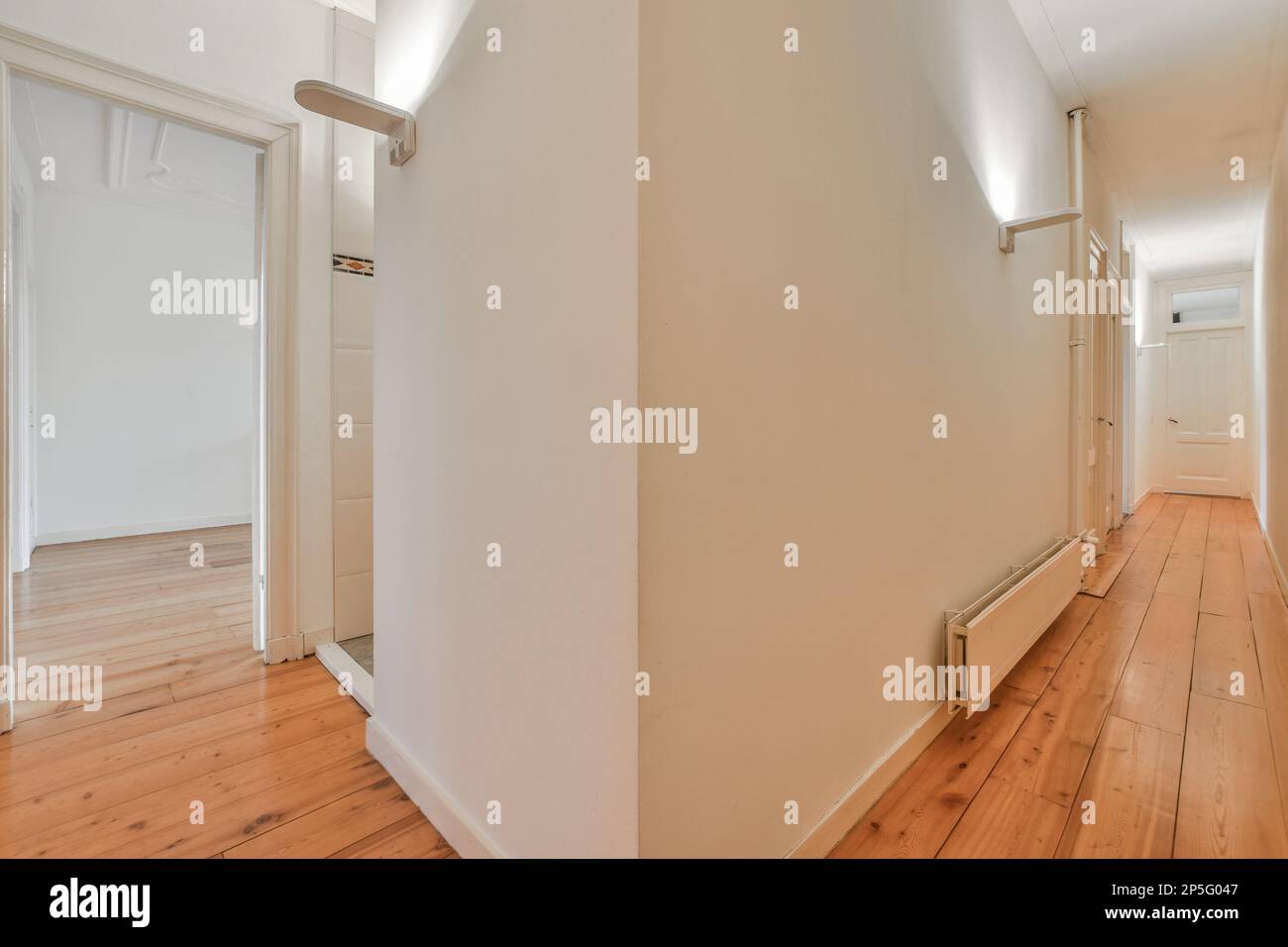 an empty room with wood flooring and white walls on the right side of ...