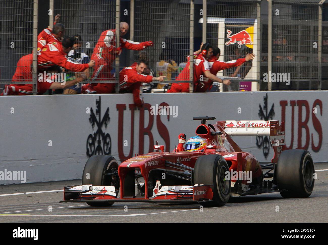 Ferrari driver Fernando Alonso of Spain celebrates in front of his team ...