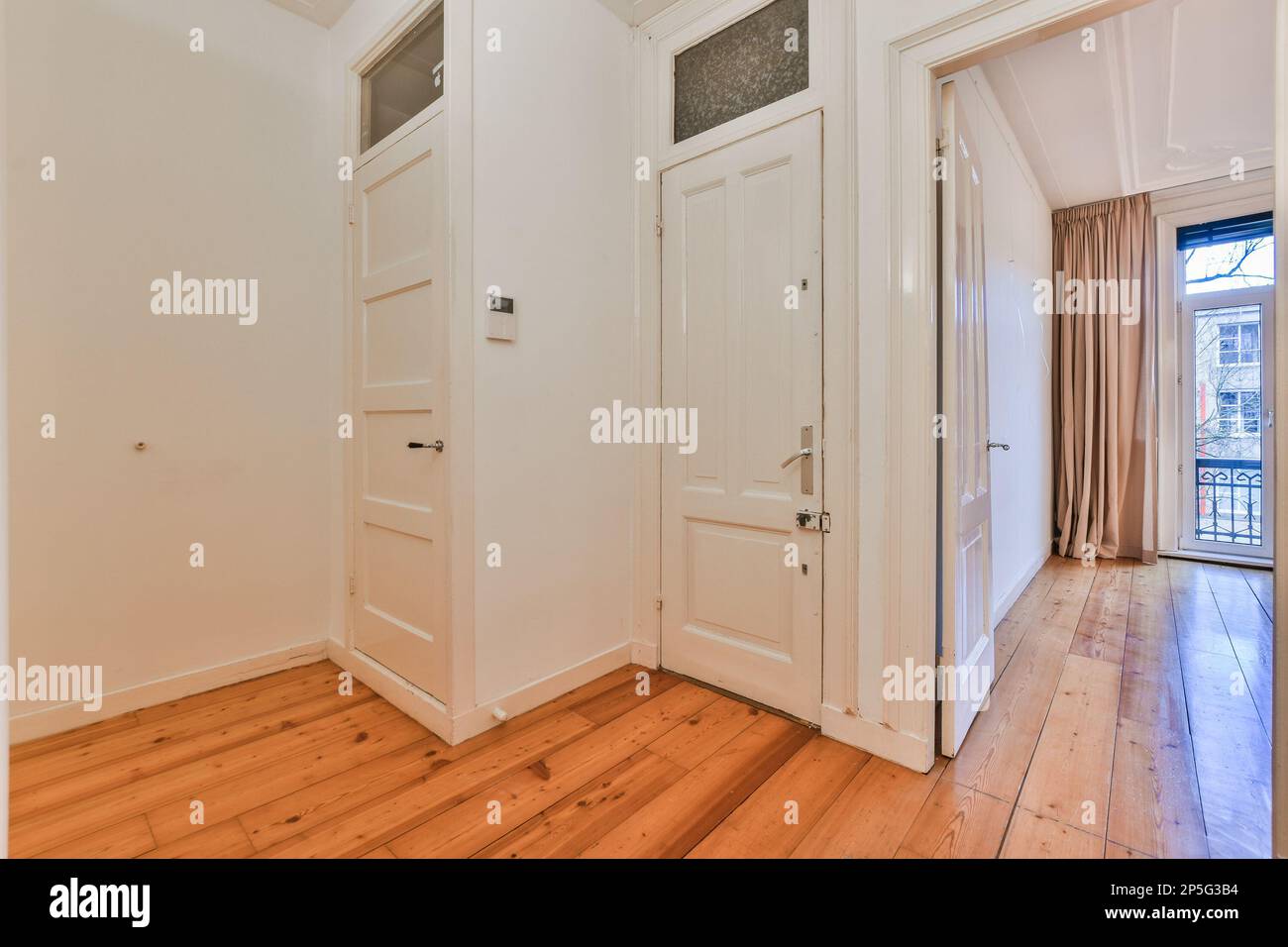 an empty room with wood flooring and white door handles on the doors ...