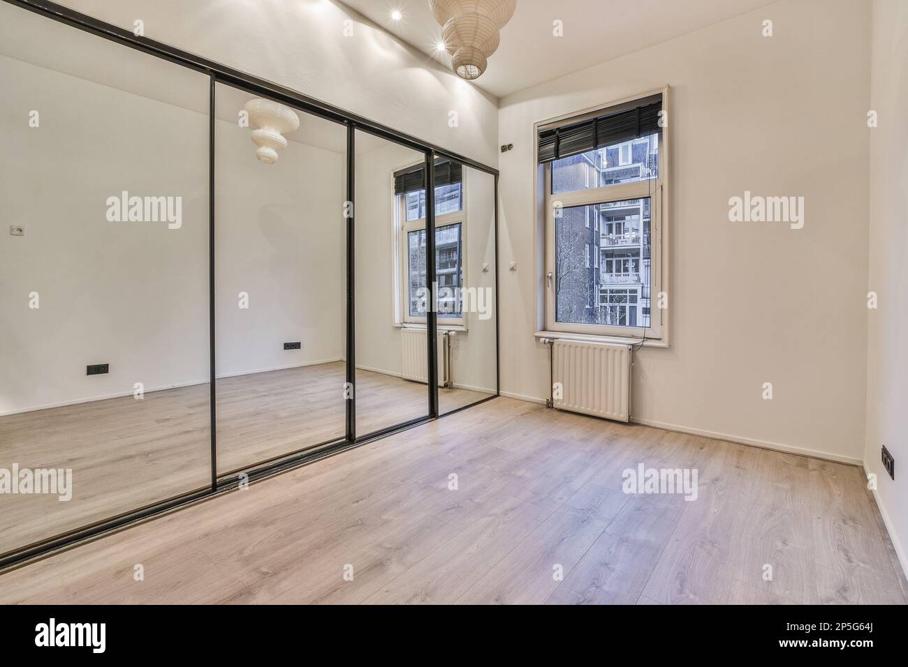 an empty room with wood flooring and large mirrors on the wall in this ...