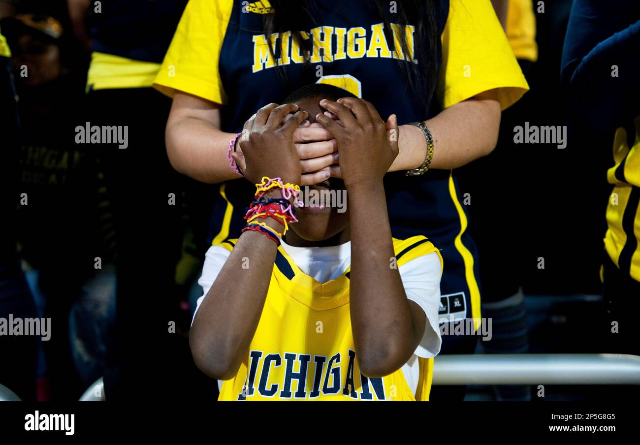 Michigan fan and eight-year-old Robert Davis Jr. shields his eyes with ...