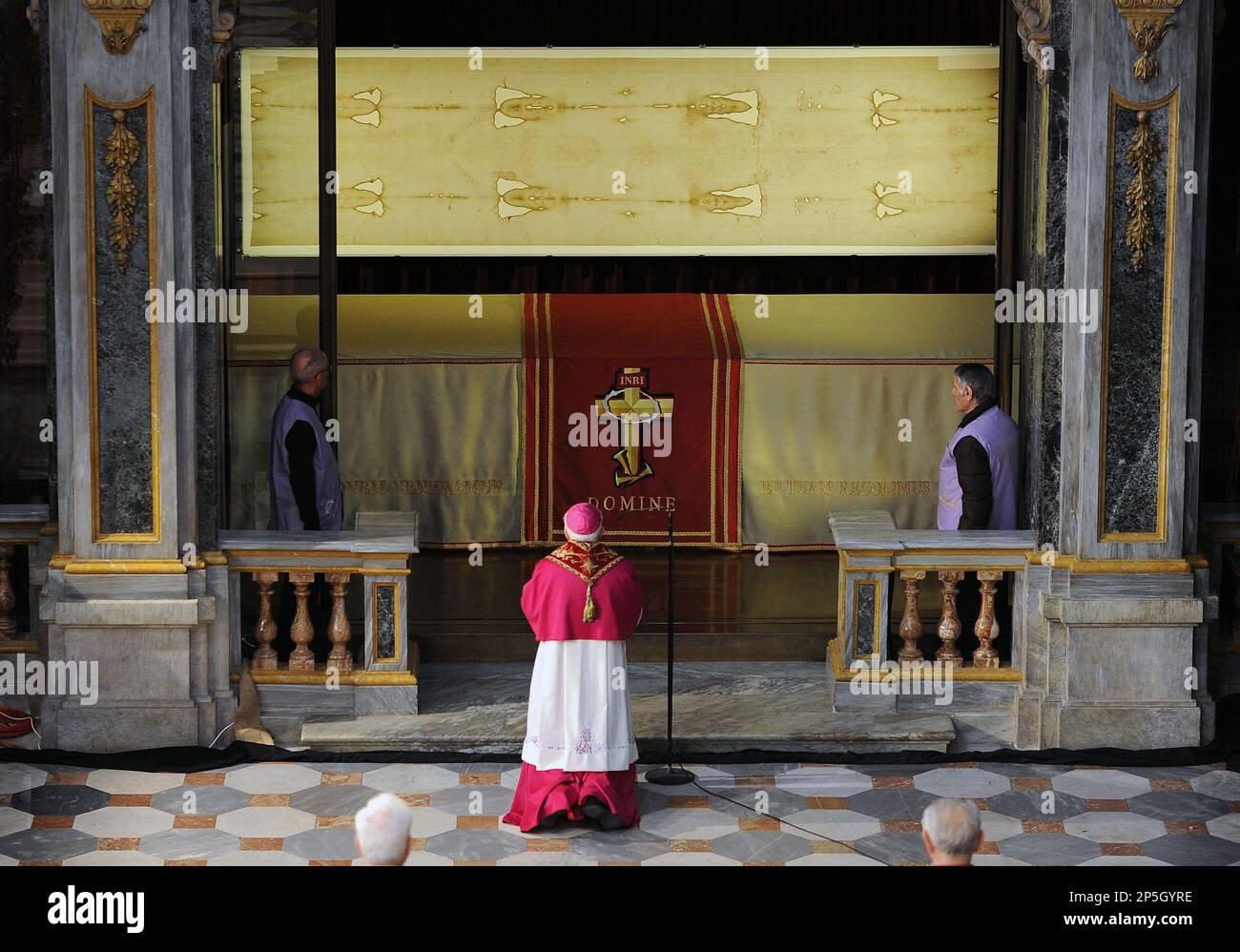 Archbishop of Turin Cesare Nosiglia, center, kneels in front of the ...