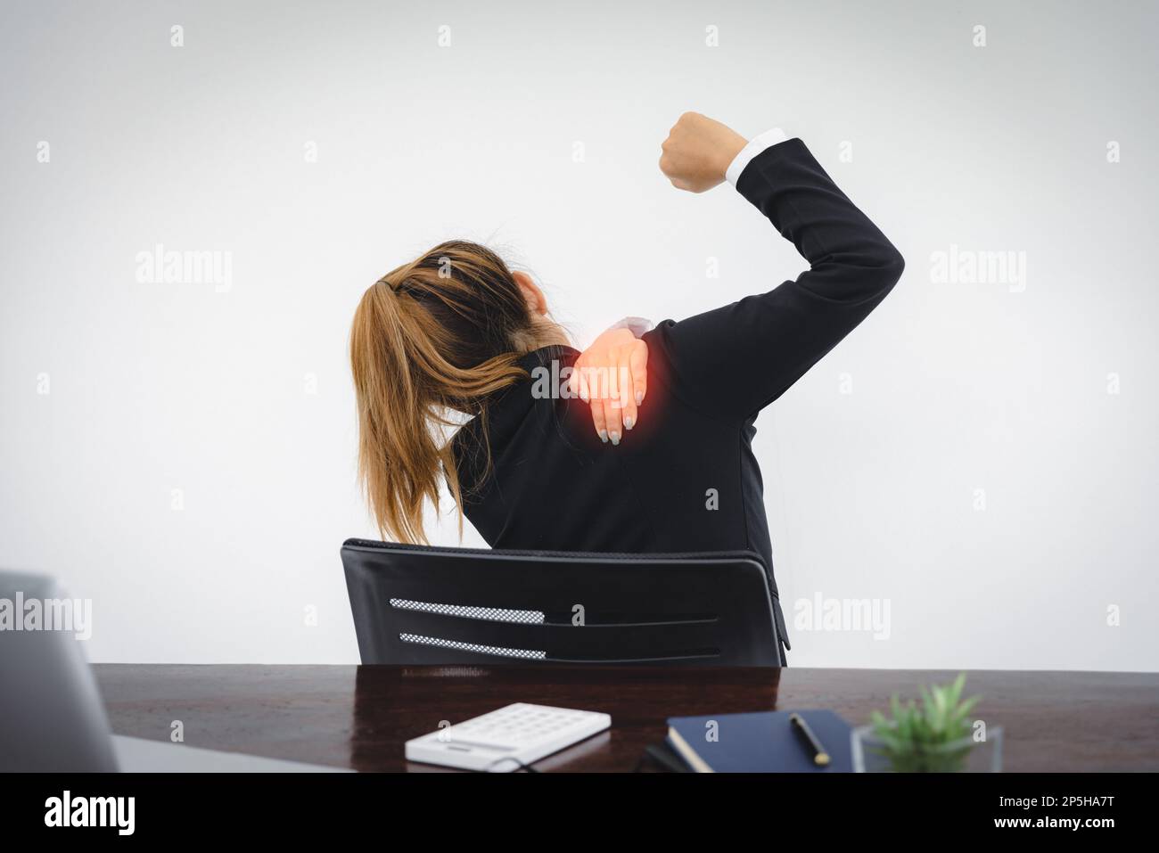 Businesswoman suffering from shoulder pain at work injury or illness ...