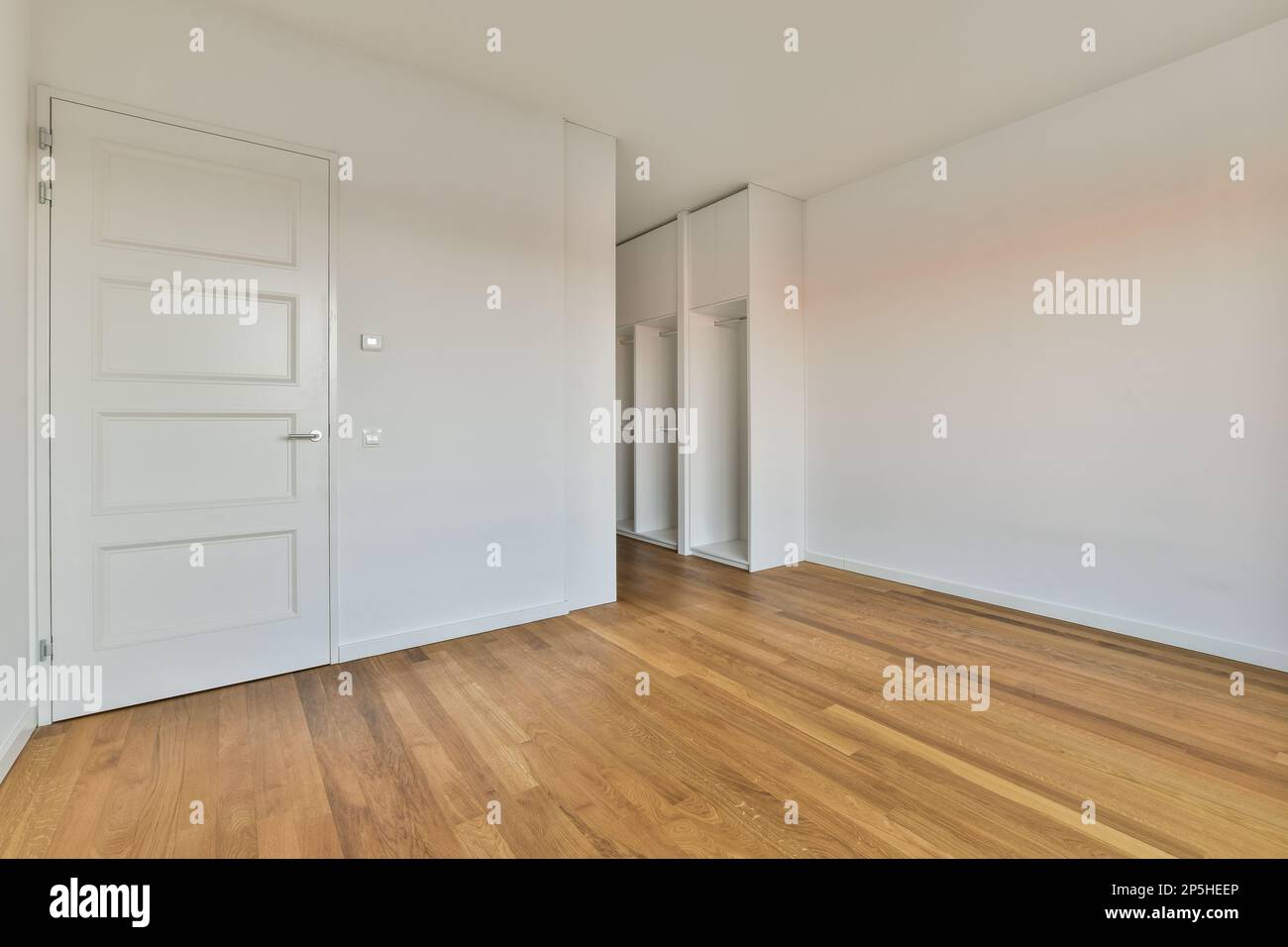 an empty room with white walls and wood flooring the door is open on ...