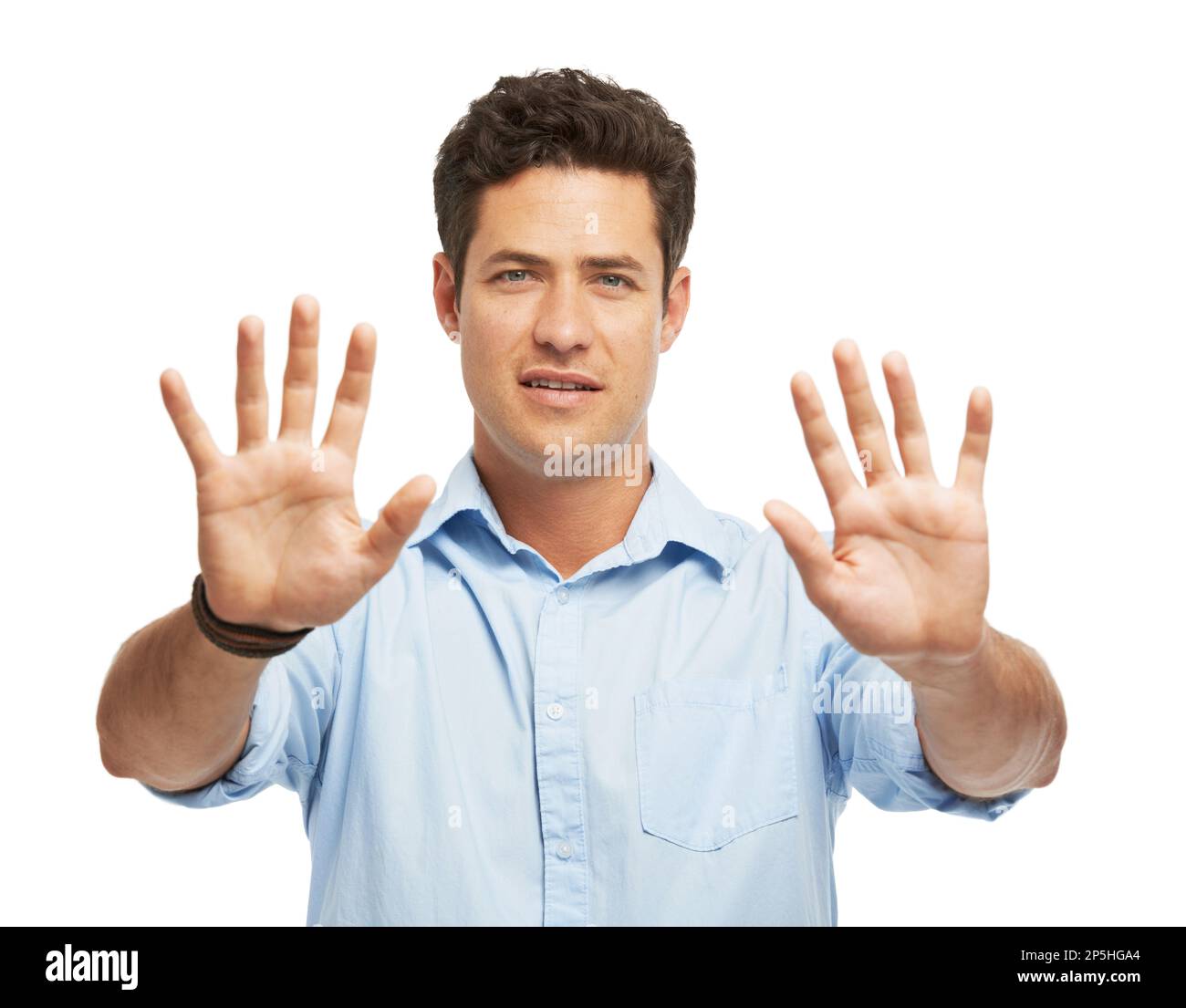 Pushing the boundaries. A young man holding out both of his palms while ...