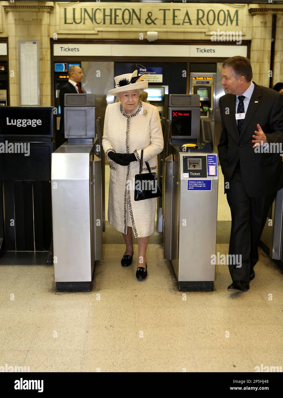 Britain's Queen Elizabeth II passes through a ticket barrier at Baker ...