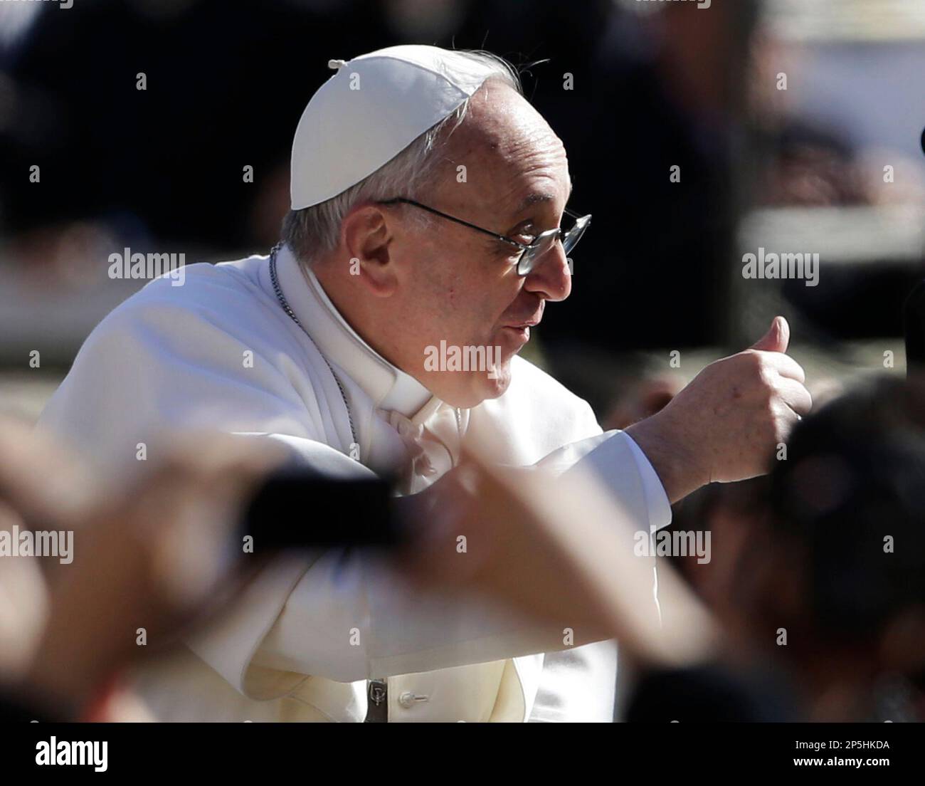 Pope Francis gives the thumbs up to the crowd as he arrives in St ...