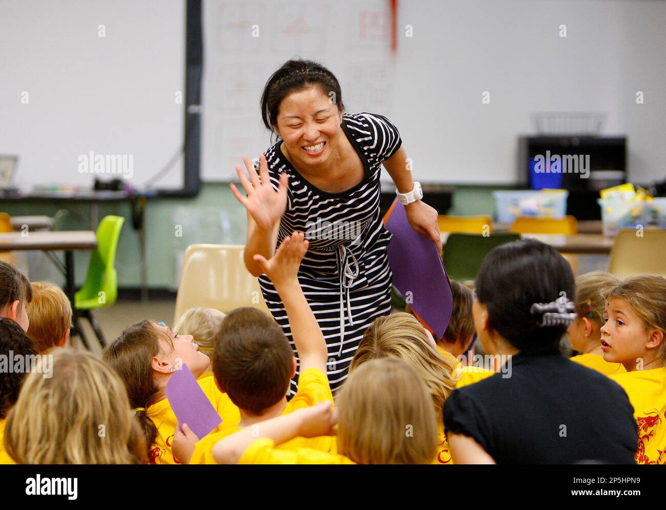 Ning Zhao gives a high five to a student during an exercise at a full ...