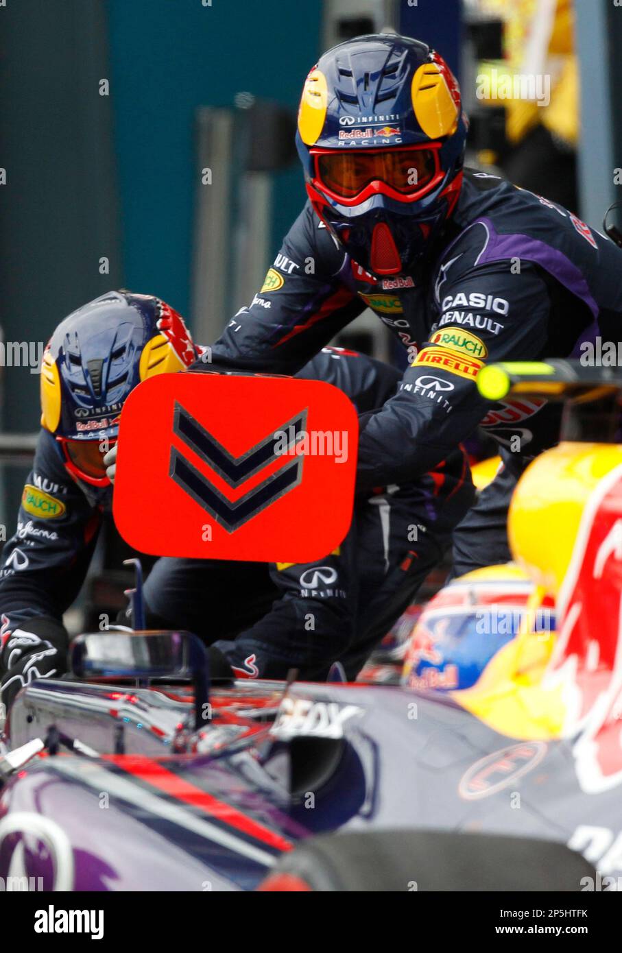 A Red Bull Formula One car controller signals to driver Mark Webber in ...
