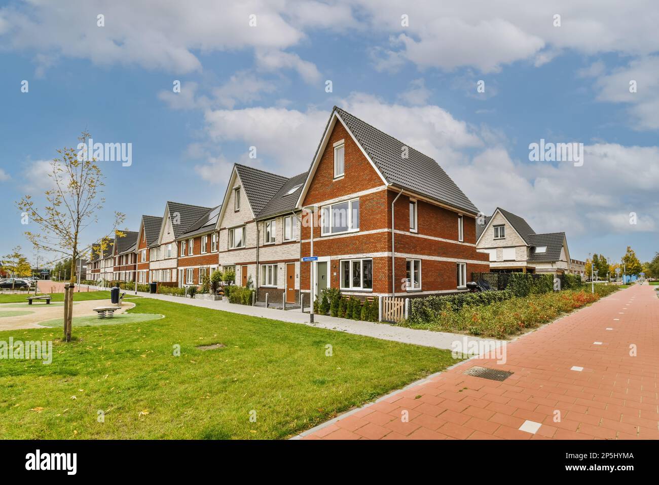 a row of houses on a sunny day with blue sky and white clouds in the ...