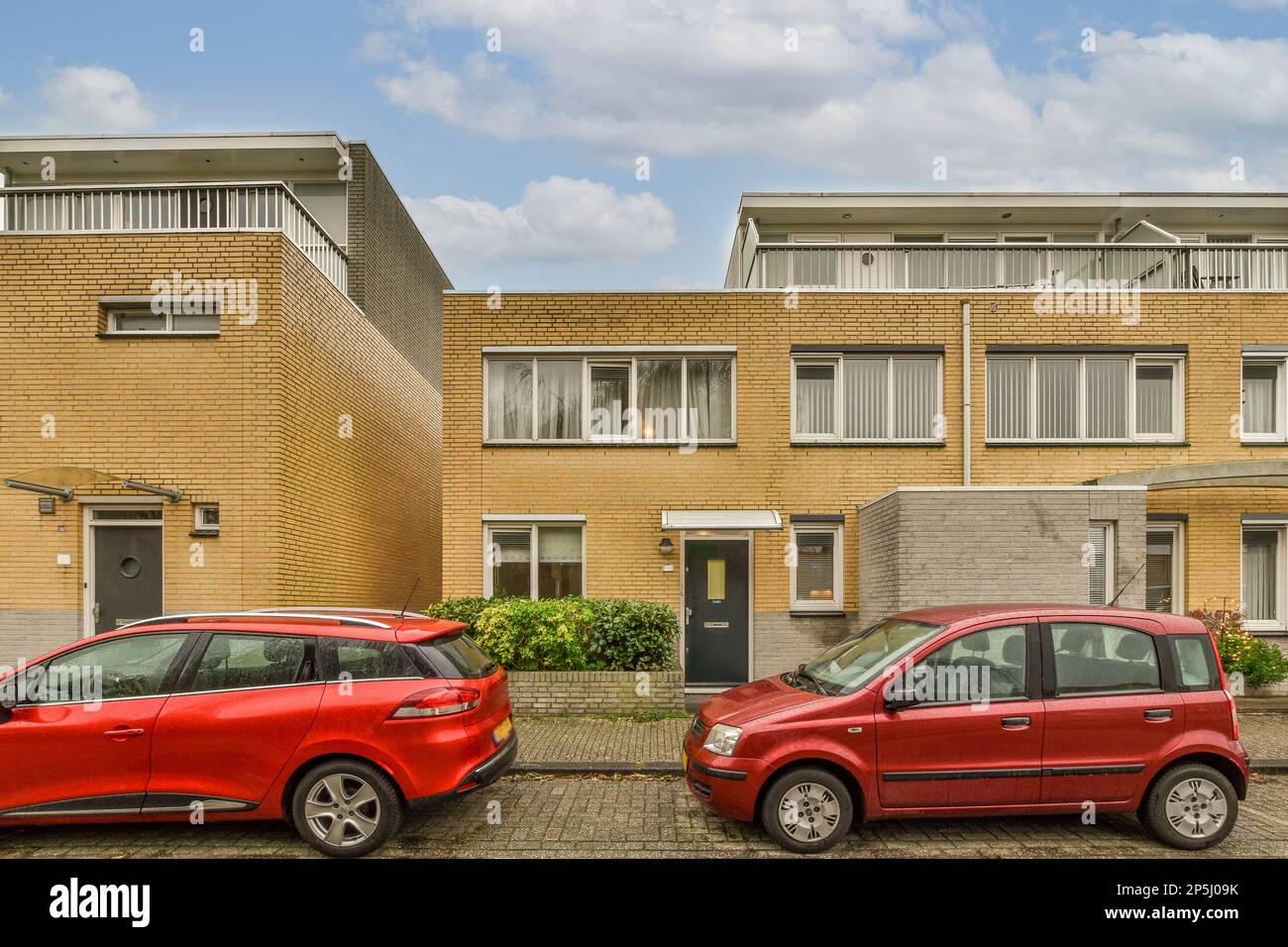 two cars parked next to each other car in front of an apartment ...