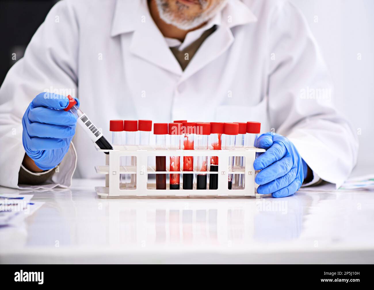 Analyzing your lifeblood. a male scientist conducting blood tests in a ...