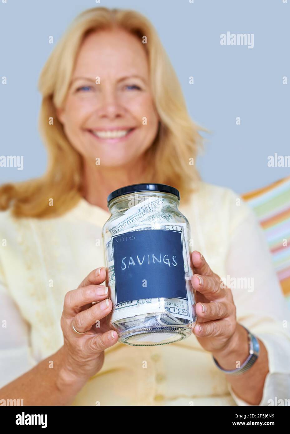 Saving up for a rainy day. Portrait of a senior woman holding a jar ...