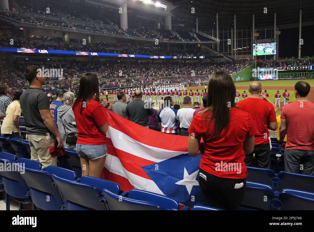 USA and Puerto Rico team members and fans listen to their respective ...