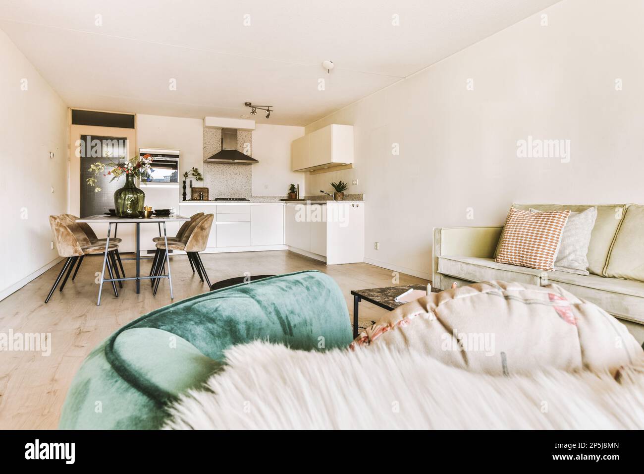a living room with a couch, table and kitchen in the photo is blured by ...