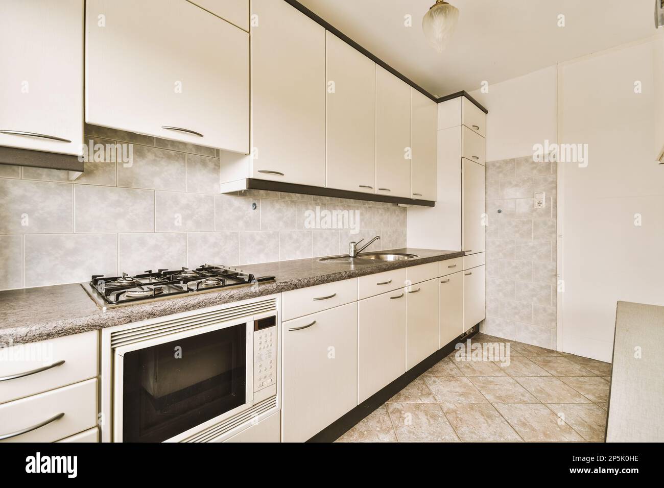 a kitchen with white cabinets and marble counter tops on the counters ...