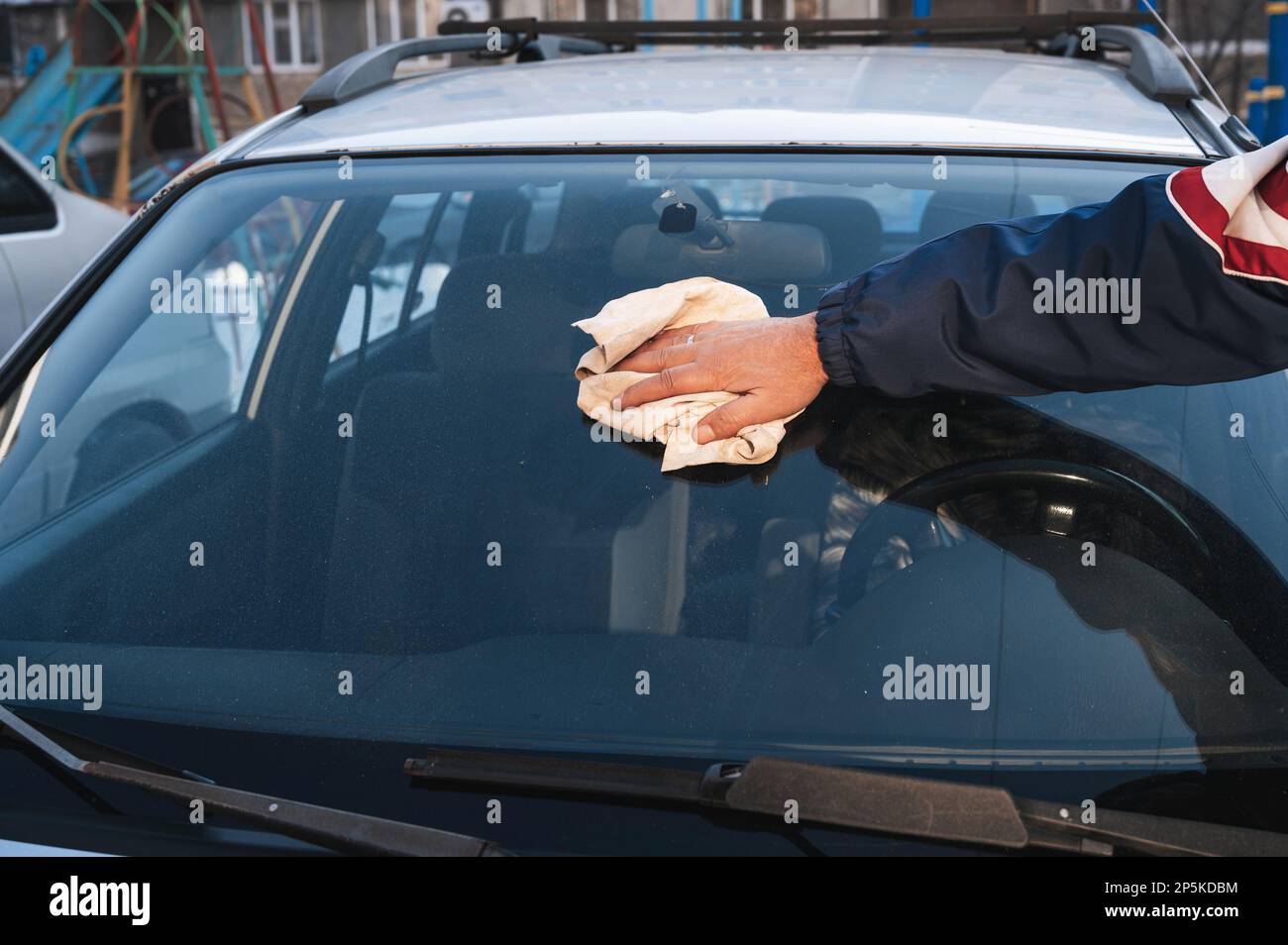 man's hand wipes the dusty windshield of a car with a napkin Stock ...