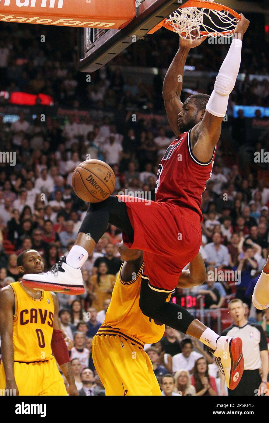 Miami Heat's Dwyane Wade, top, dunks against Cleveland Cavaliers' C.J ...