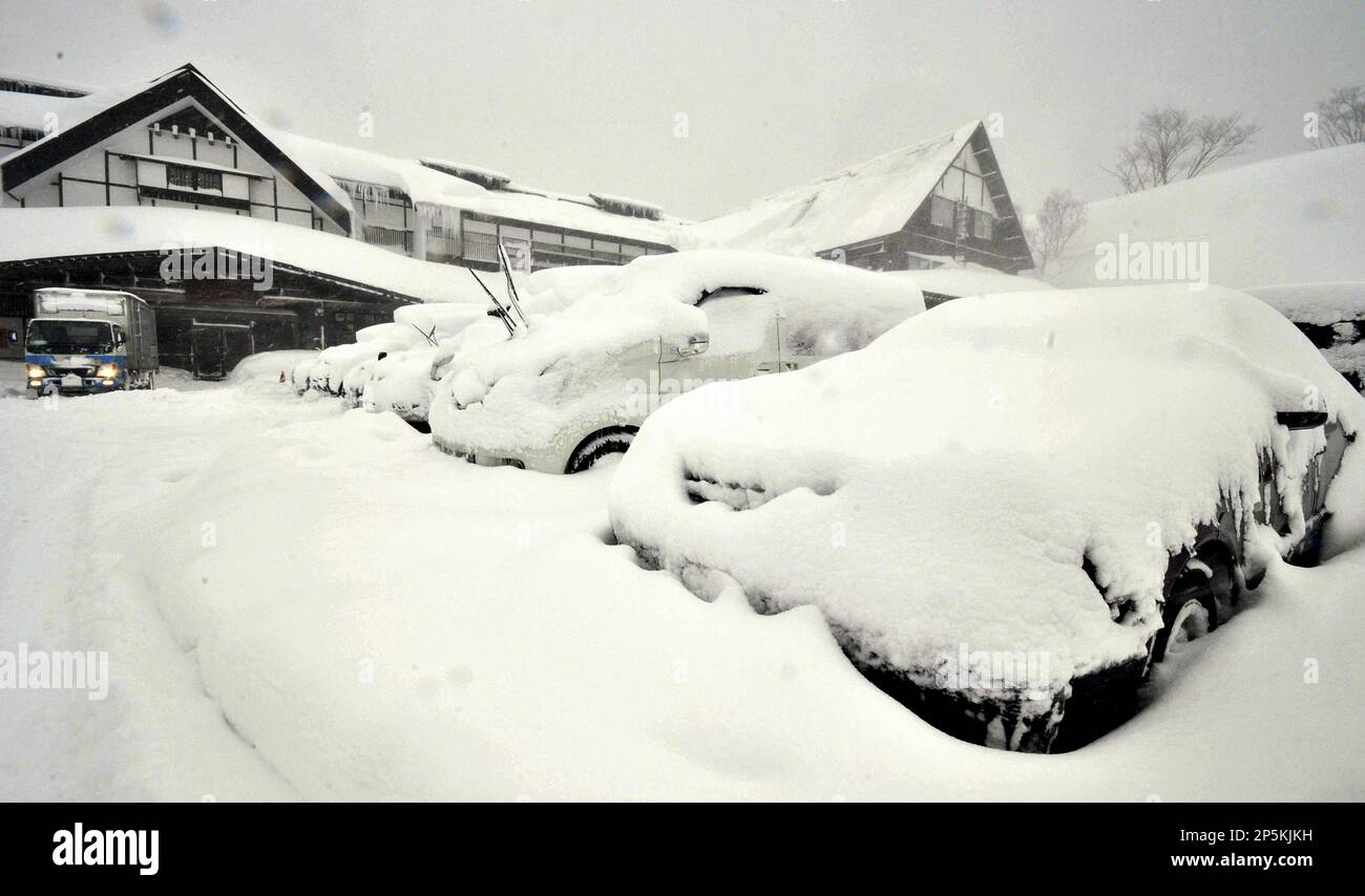 Heavy snow blankets a building and cars at the Sakayu hot spring resort ...