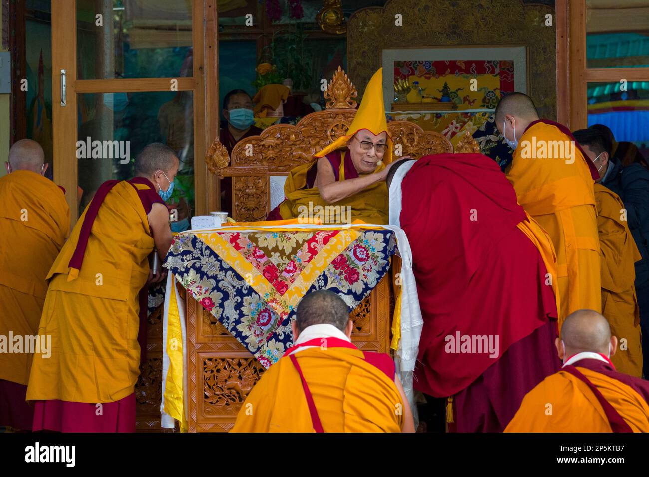 Tibetan spiritual leader the Dalai Lama in a ceremonial yellow hat ...