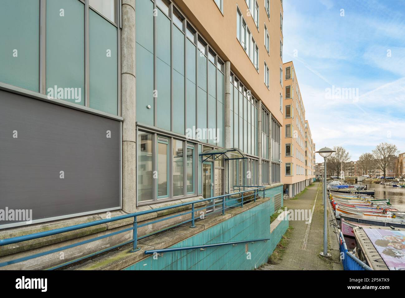 boats parked in front of a building on the side of a river with blue ...