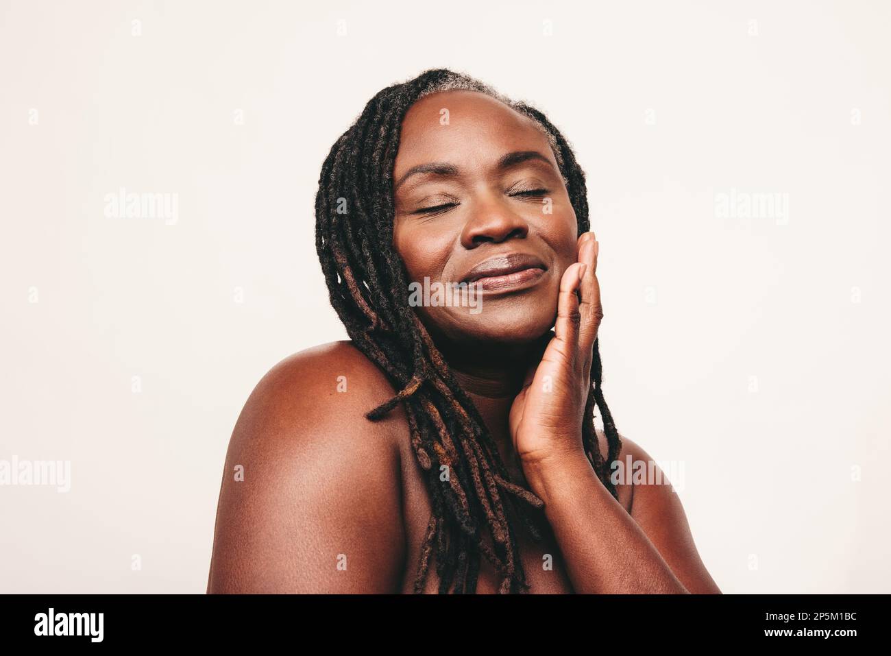 Beautiful Woman With Dreadlocks Touching Her Flawless Skin With Her