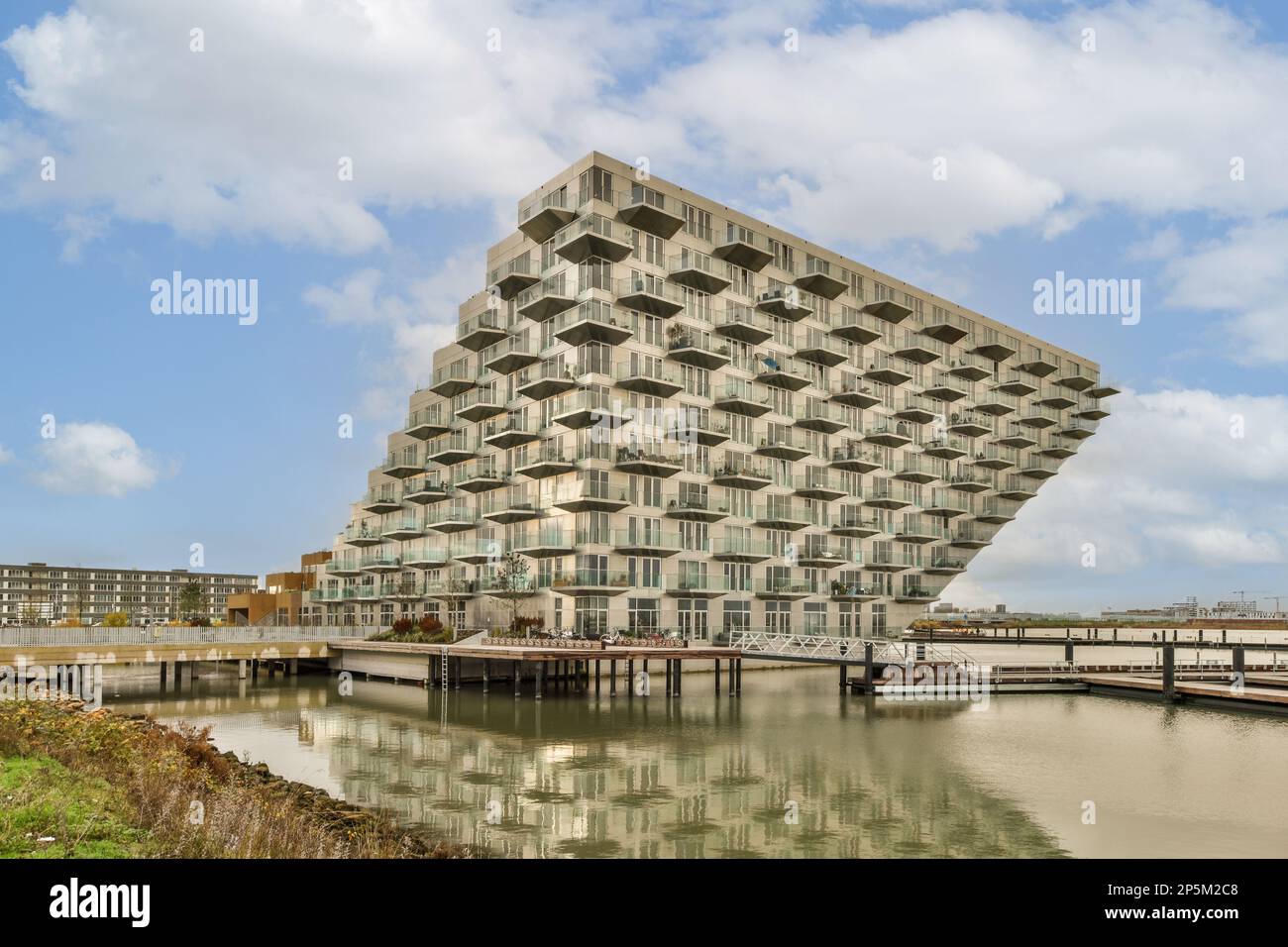 an office building on the water's edge, with its reflection in the ...