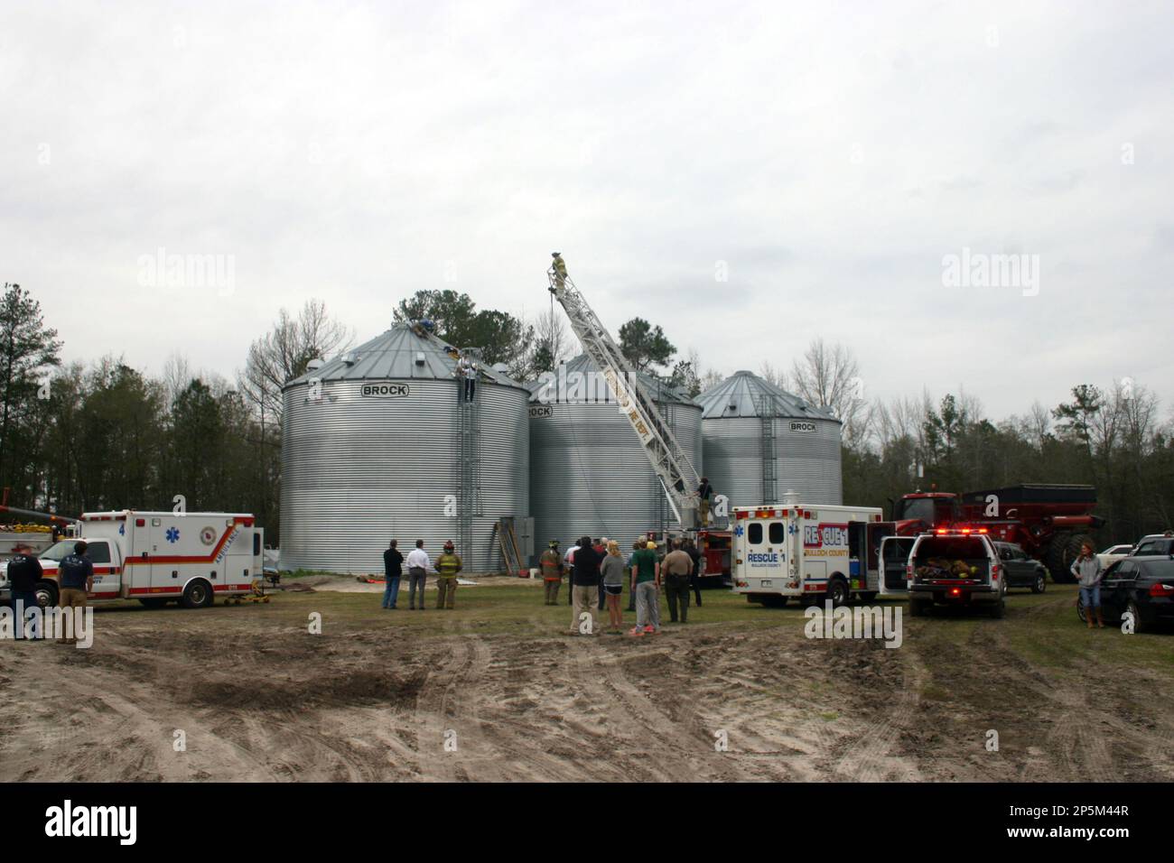 Emergency personnel work to rescue a trapped farmer partially buried in ...