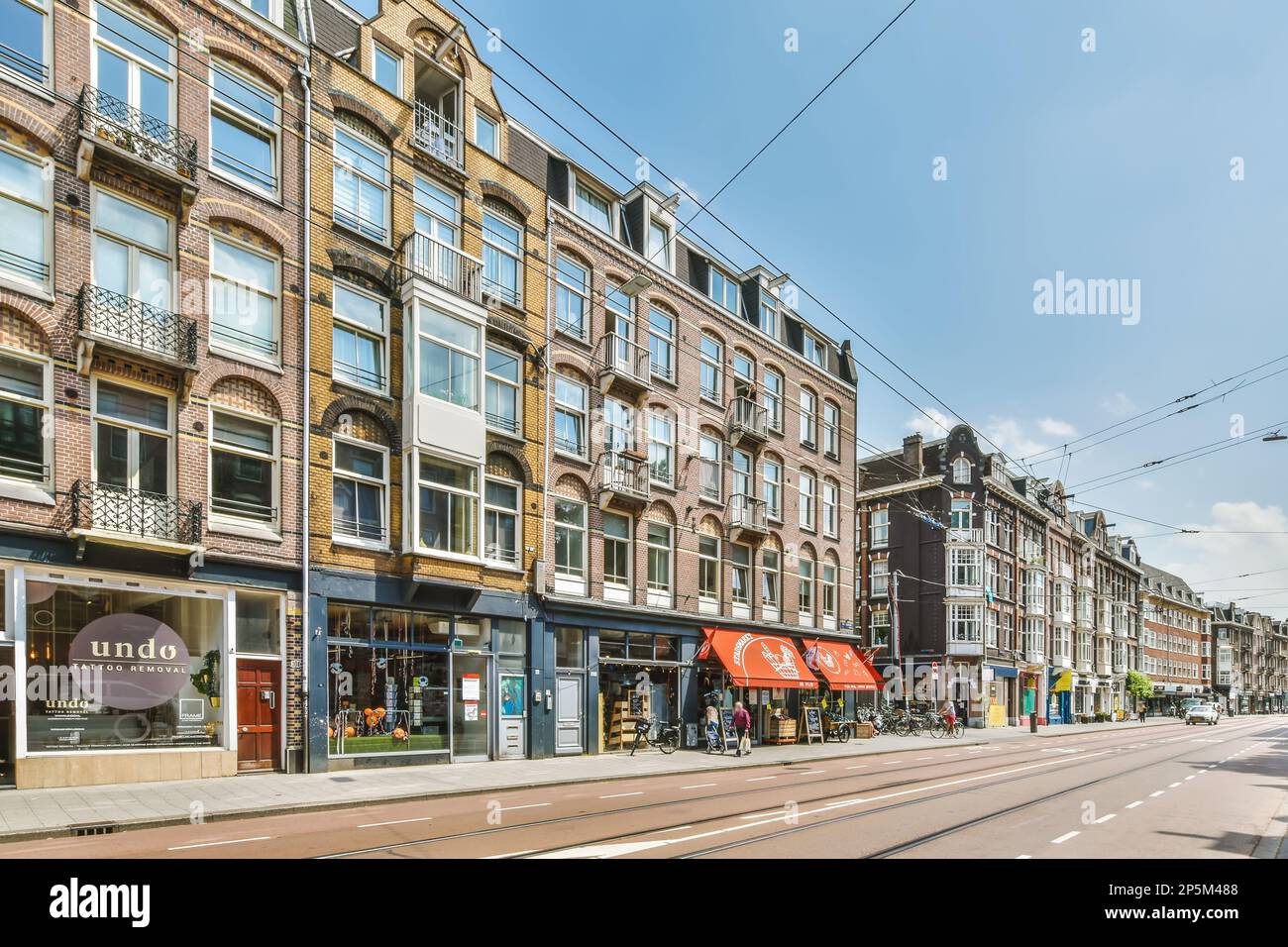 a city street with buildings on both sides and people walking down the ...