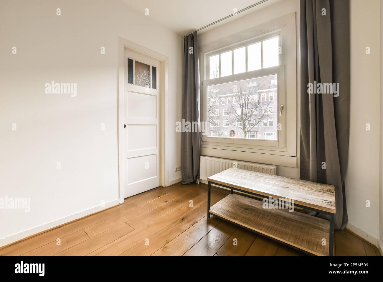 an empty room with a bench in front of the window and a door to the ...