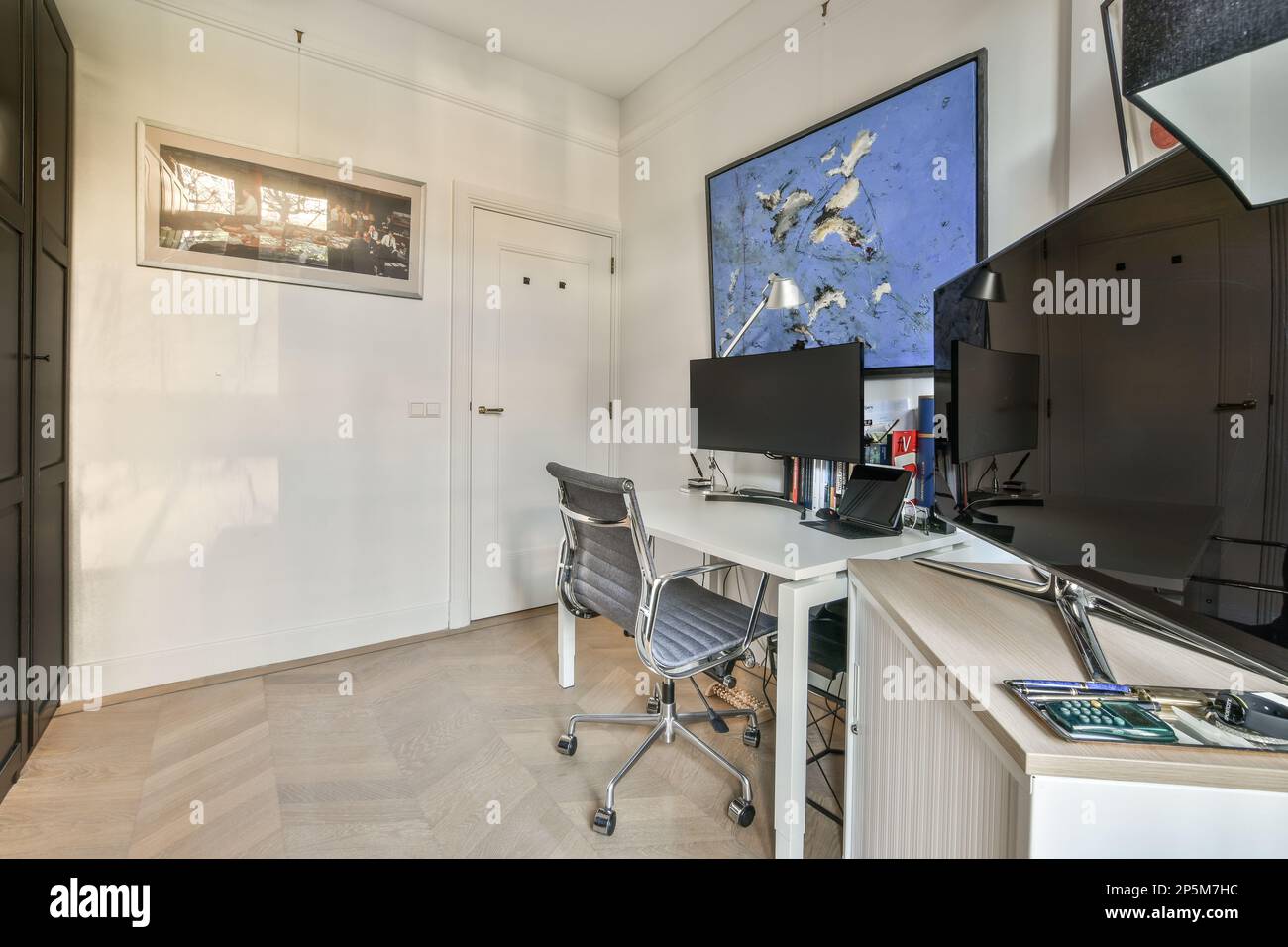 an airplane on the wall above a desk with two computer monitors and a ...