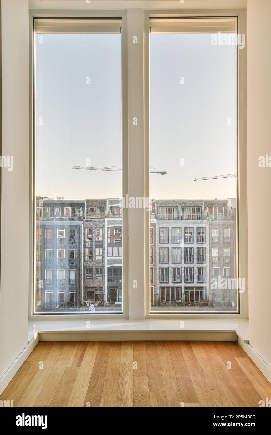 an empty room with wooden floors and large windows looking out onto the ...