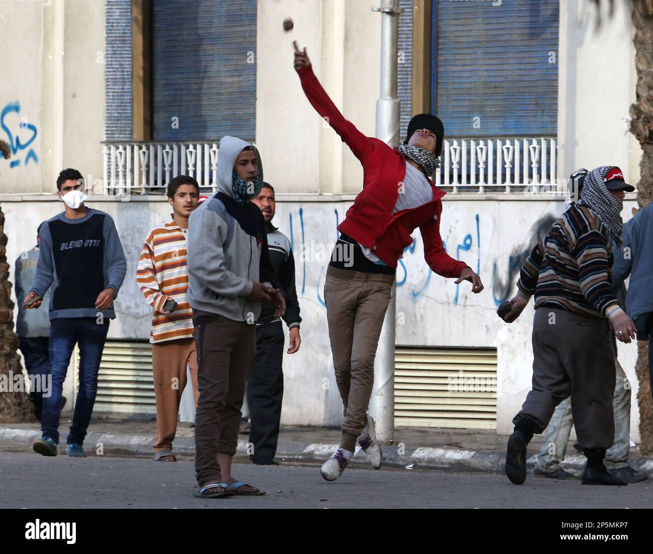Anti-government protesters hurl a stone agaisnt security forces in ...