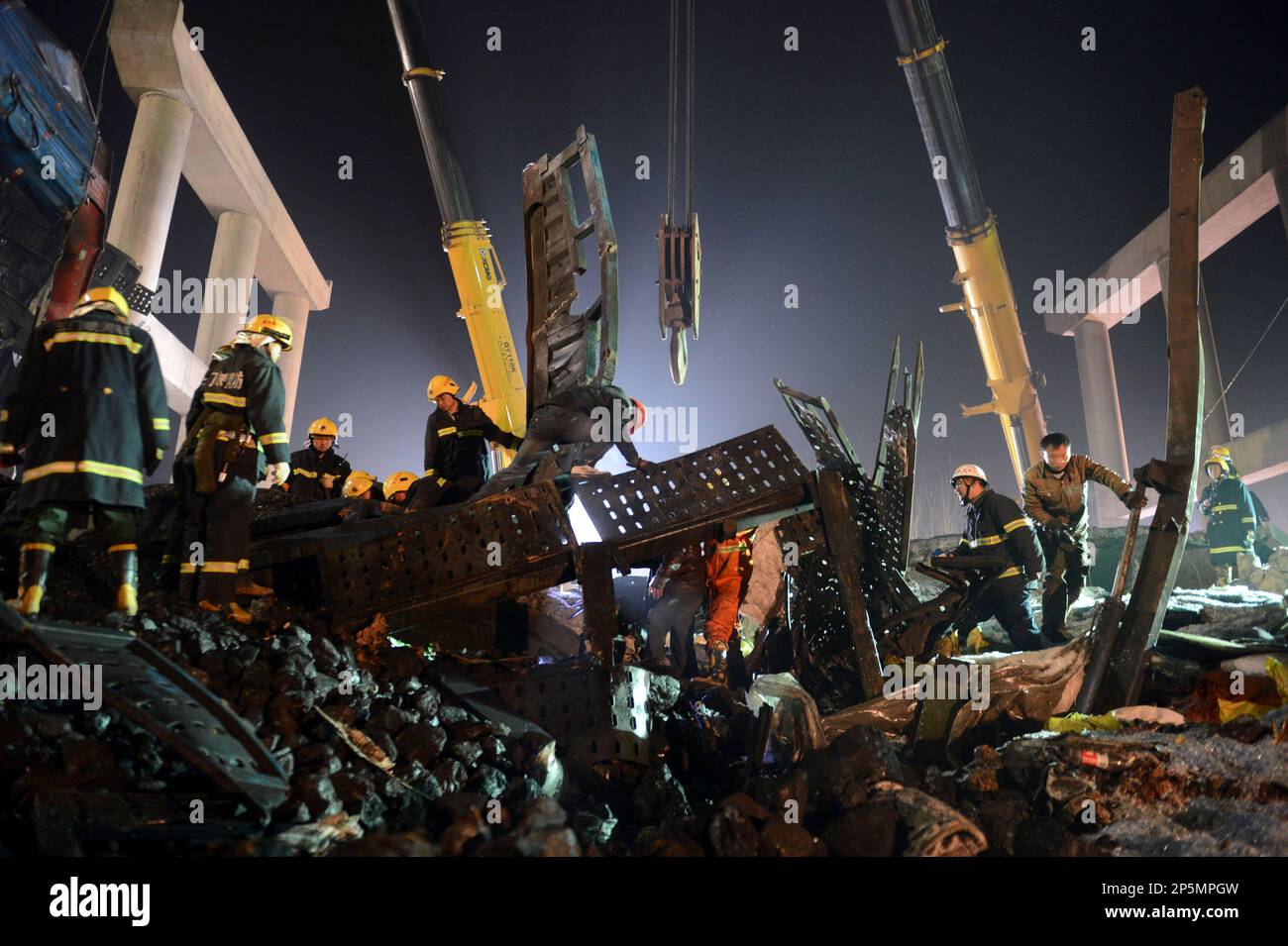 Rescuers work at the accident site where an expressway bridge partially ...