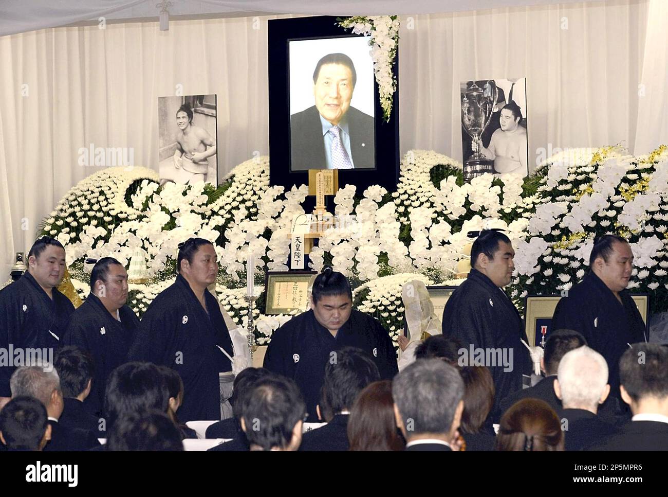 A group of sumo wrestlers visit the funeral ceremony with a portrait of ...