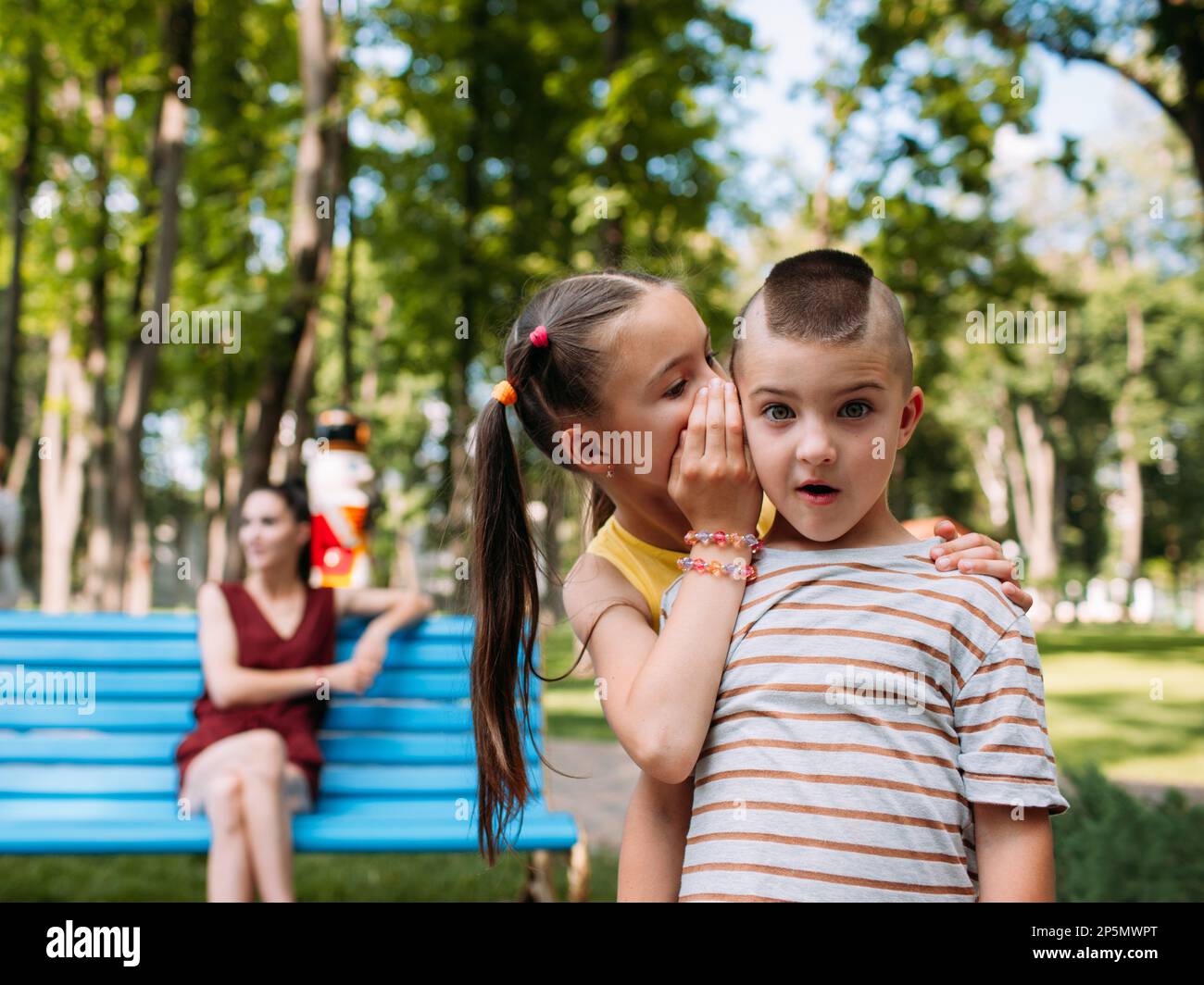 Children secrets behind mother back at park Stock Photo - Alamy