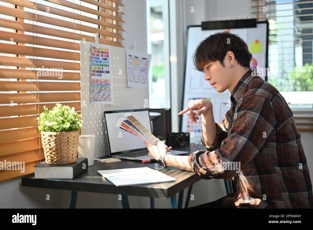Creative designer choosing colors from palette guide during working on ...