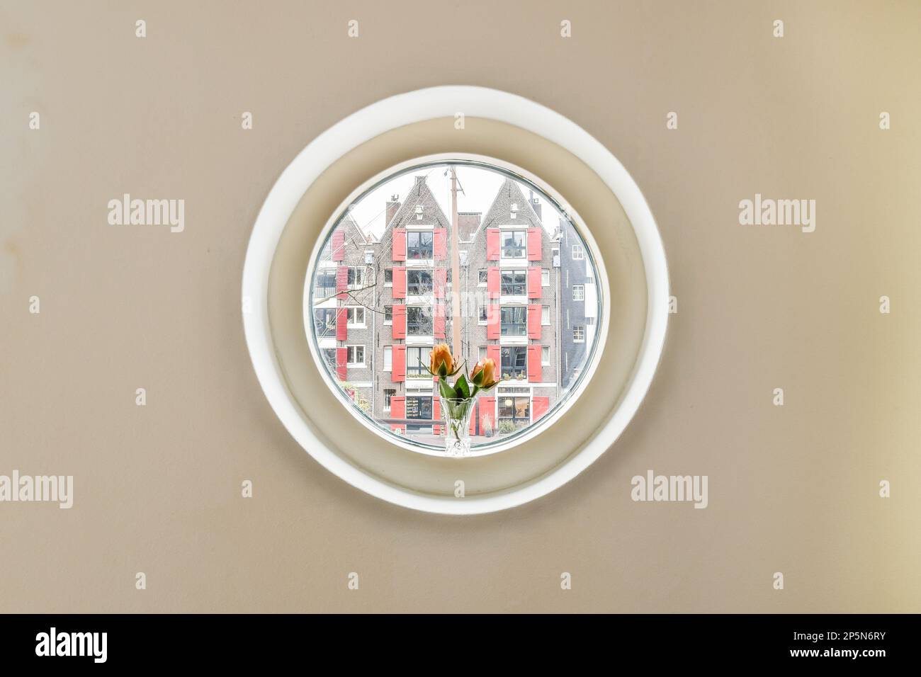 a round window with a flower in it's center and the view of an urban ...