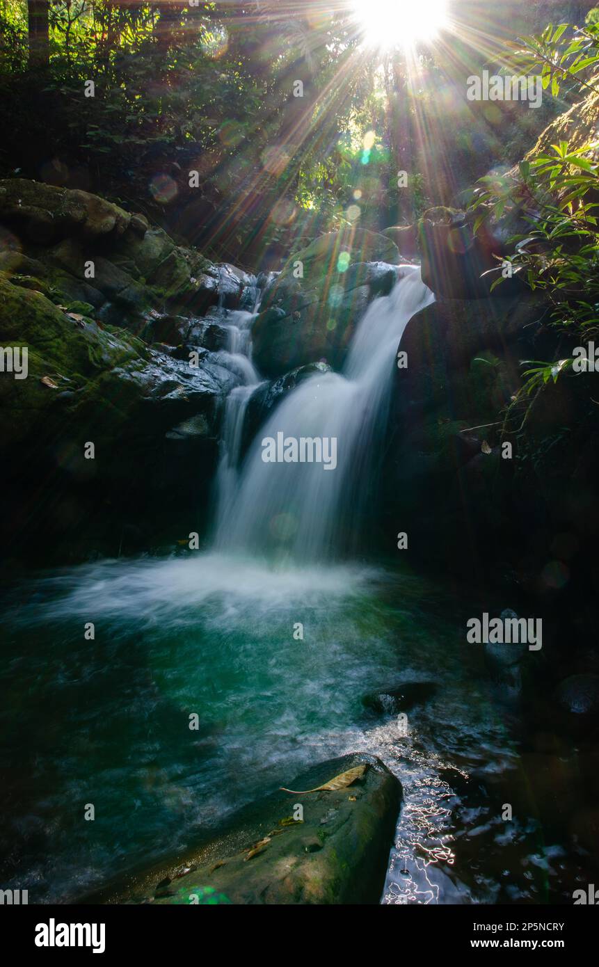 smooth waterfall emerald color with sunray Stock Photo - Alamy