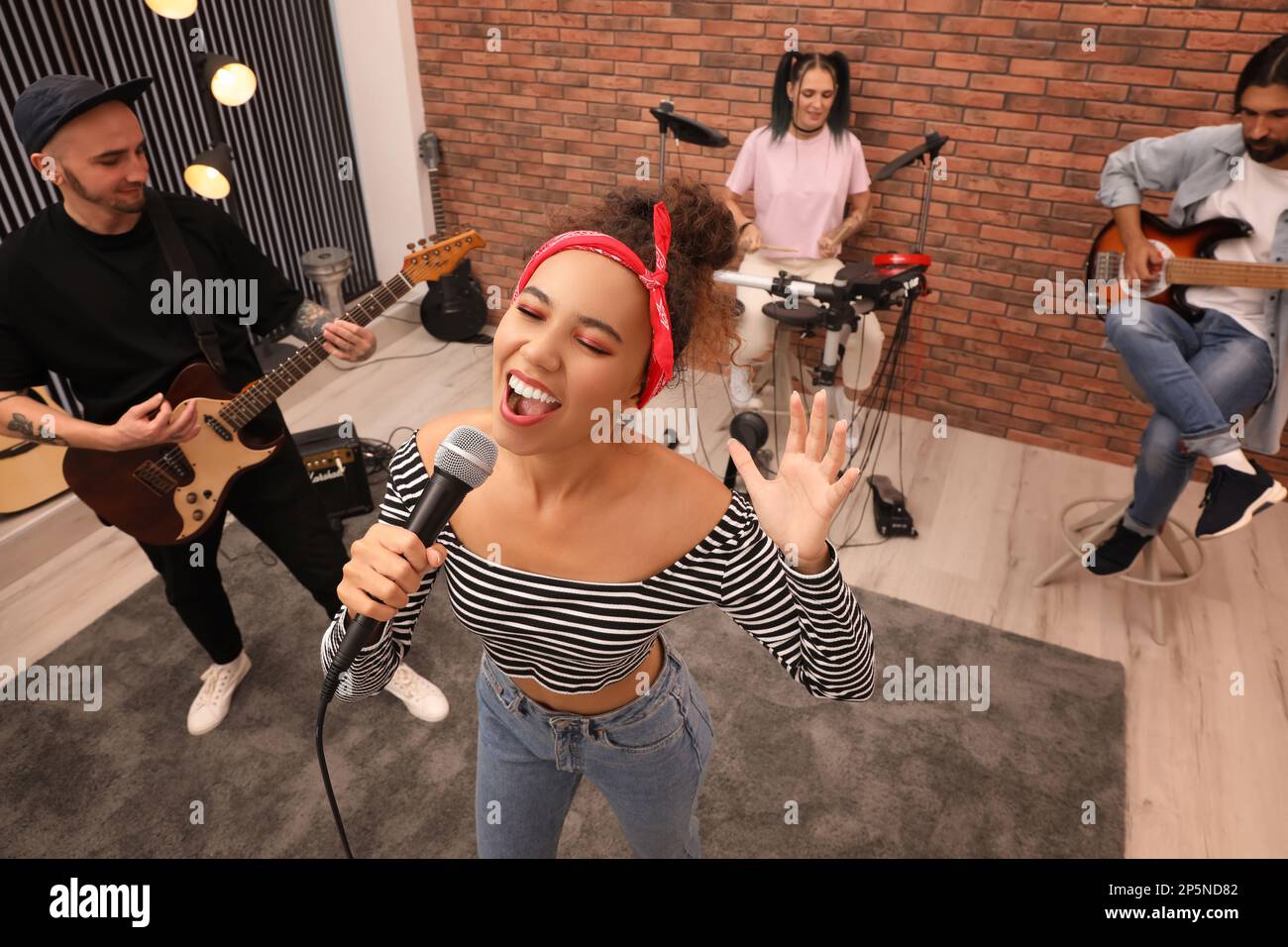 Music band performing in modern recording studio Stock Photo - Alamy