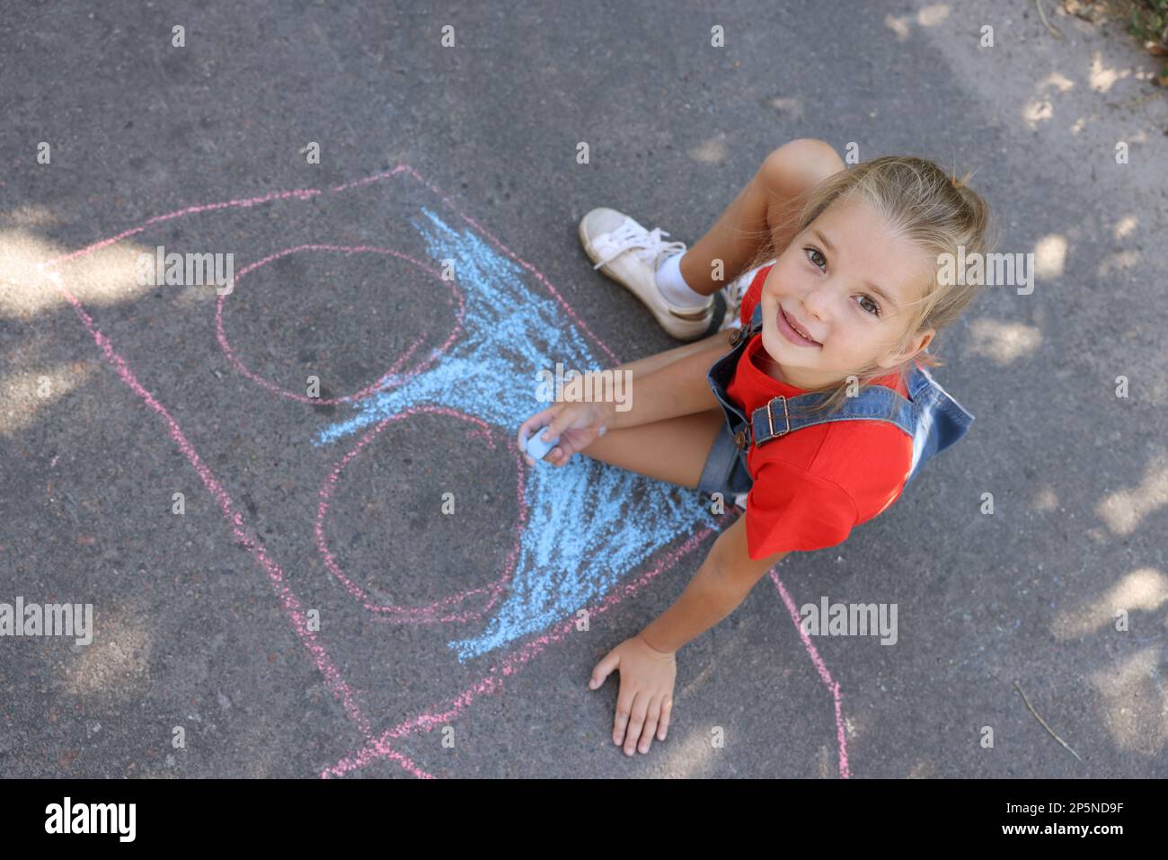 Cute little child drawing with colorful chalk on asphalt Stock Photo ...