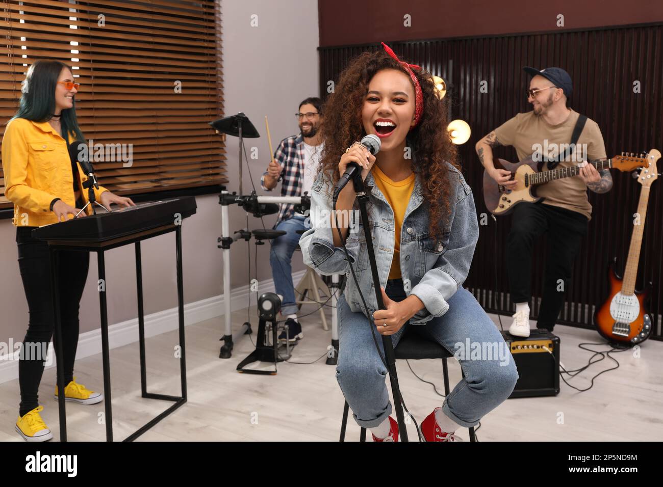 Music band performing in modern recording studio Stock Photo - Alamy