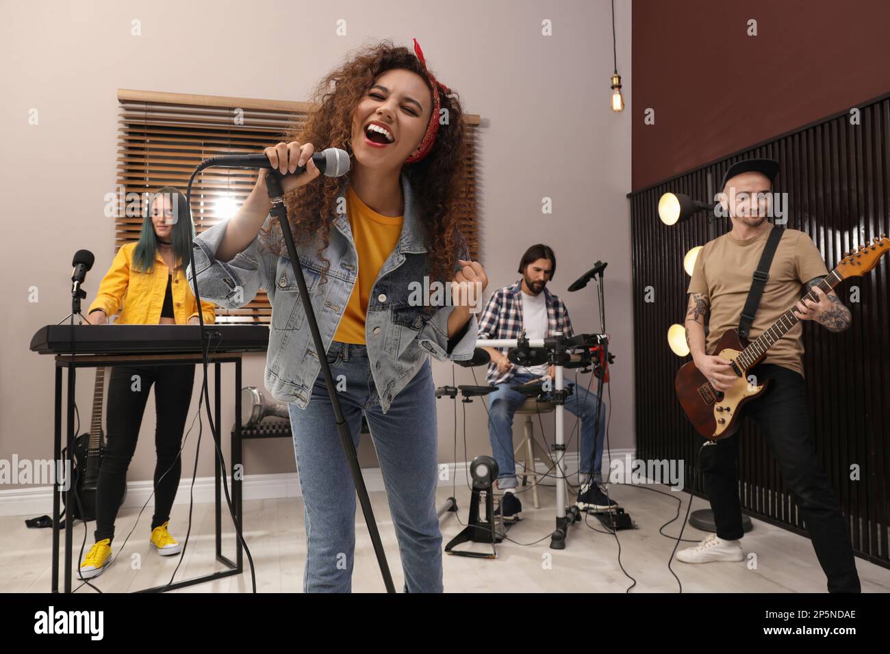 Music band performing in modern recording studio Stock Photo - Alamy