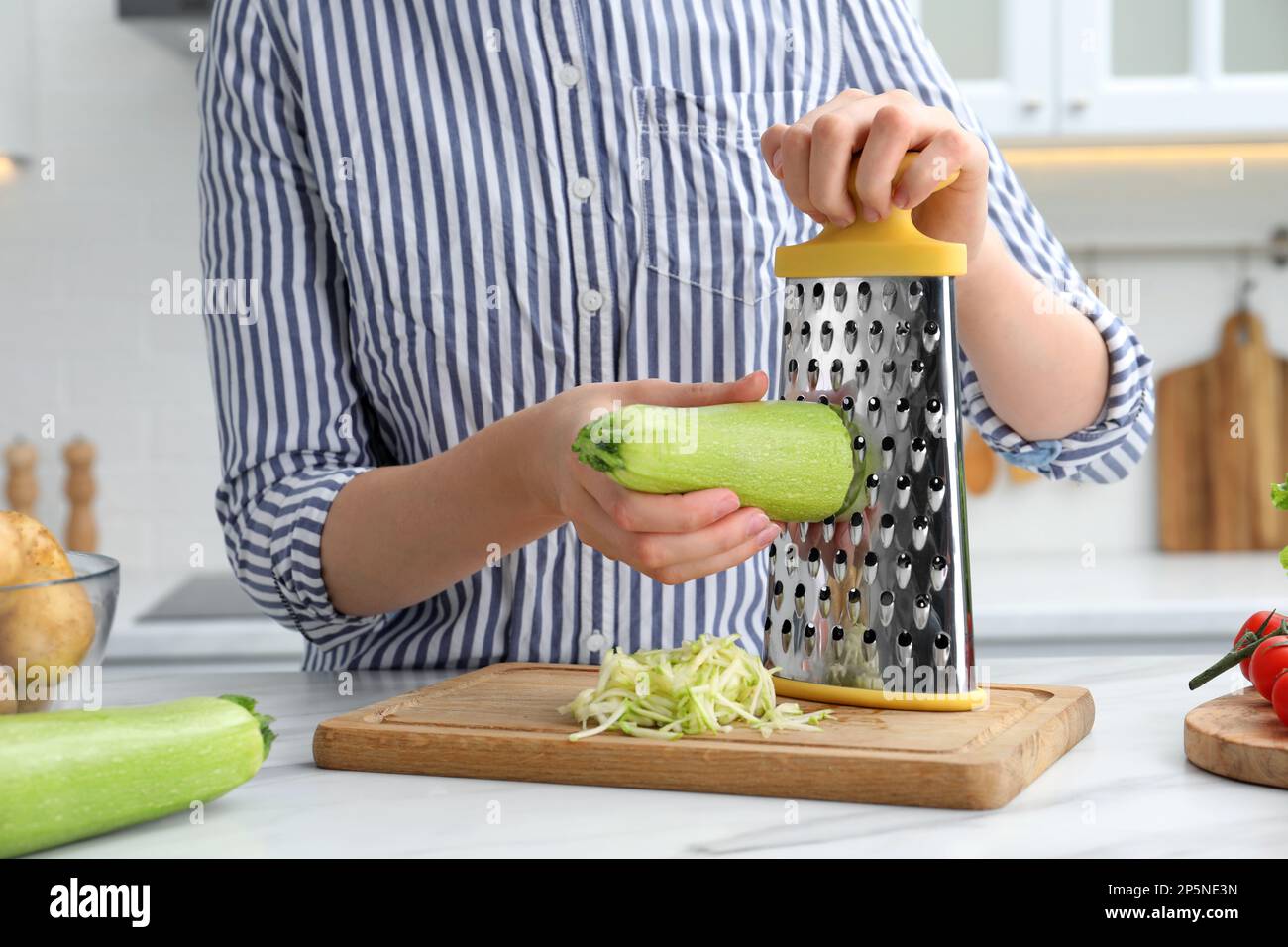 Woman grating zucchini table hi-res stock photography and images - Alamy