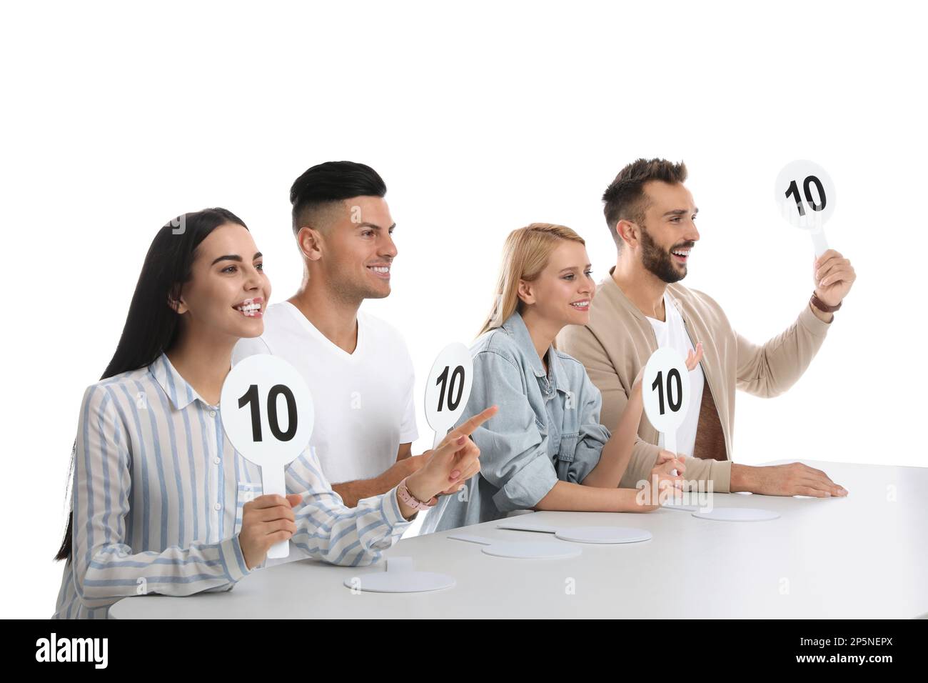 Panel of judges holding signs with highest score at table on white ...