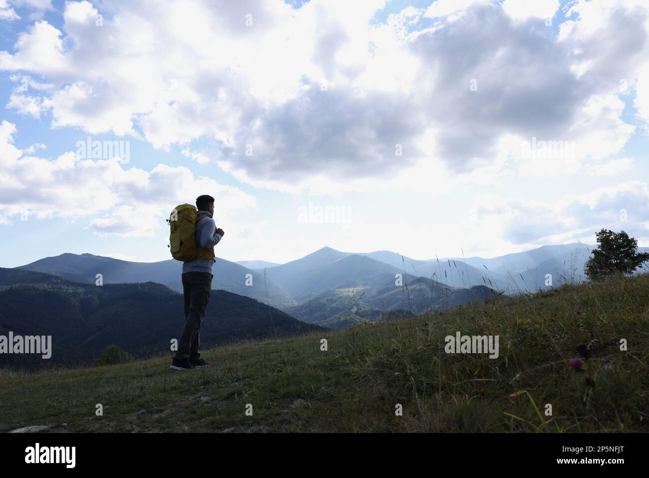 Tourist with backpack enjoying mountain landscape, space for text Stock ...